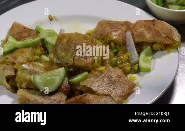 chicken Mataba on a white plate and a bowl of dipping sauce next to it ...