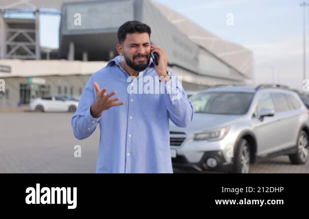Nervous, angry man making phone call, arguing, while standing against ...