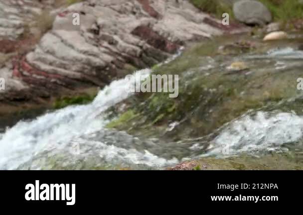 Purest transparent water in a mountain river flowing among the stones ...