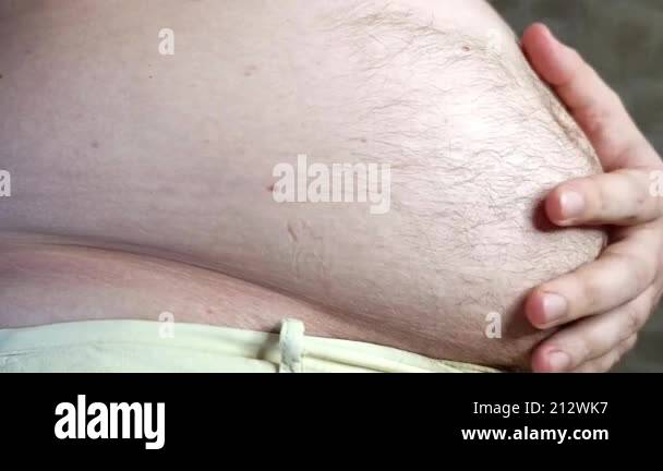 Guy examines his big belly. Concept of body positivity and weight gain ...