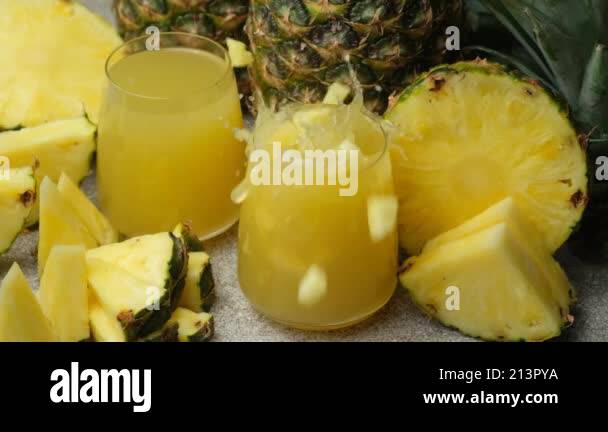 Pieces of fresh pineapple fall into pineapple juice, juice splash slow ...