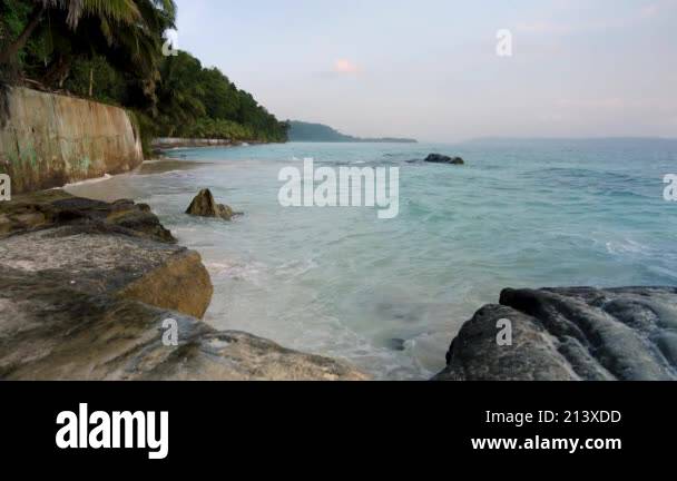 sea wave crashing at rocky beach with bright cloudy sky at dawn from ...