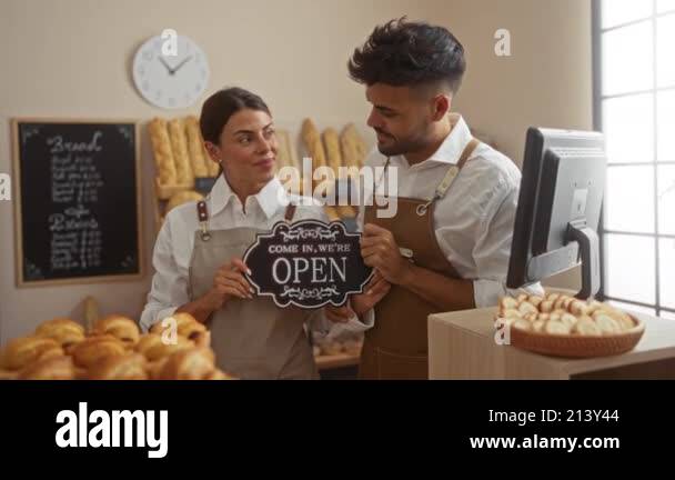 Man and woman bakers working together in a bakery shop with bread and ...