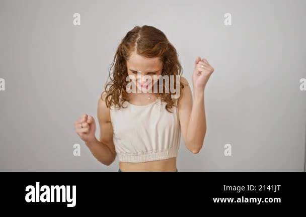 Joyful young woman stands victorious, celebrating and jumping with ...