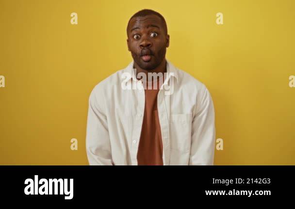 African american man wearing shirt standing in front of yellow ...