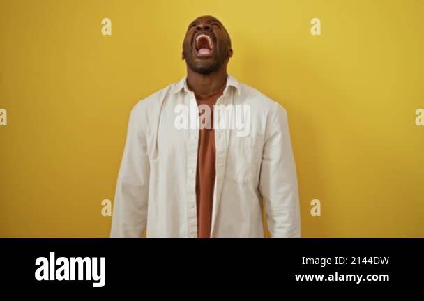 Angry african american man standing isolated in yellow background ...