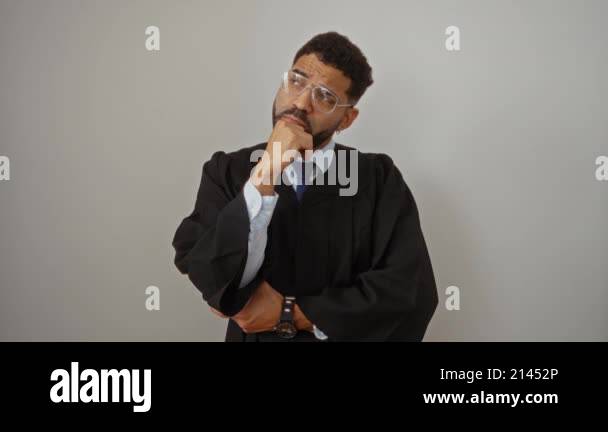 Judge, young hispanic man in gown, standing and thinking with a pensive ...