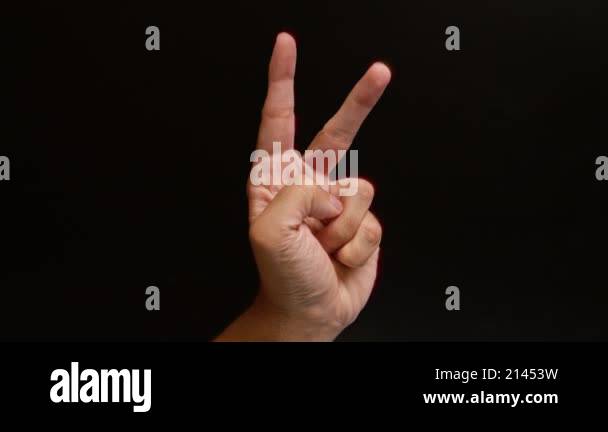 Man's hand gesturing numbers in front of a black background indicating ...