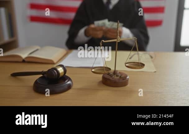 Judge counting money at a desk in a courtroom with a gavel, scales of ...
