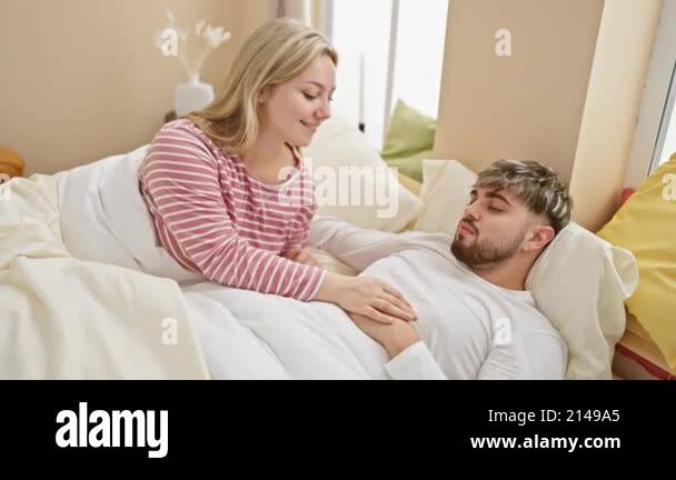 A loving couple shares tender moments in a cozy bedroom, embodying ...