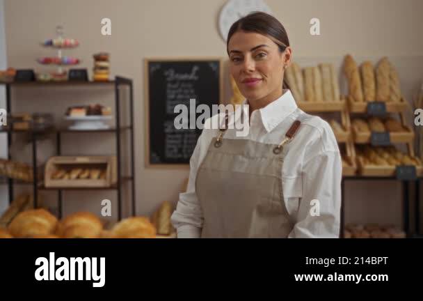 Man and woman in aprons embrace in a cozy bakery filled with fresh bread and pastries ...
