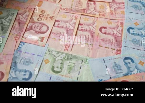 Thai banknotes of various denominations spread out, representing ...