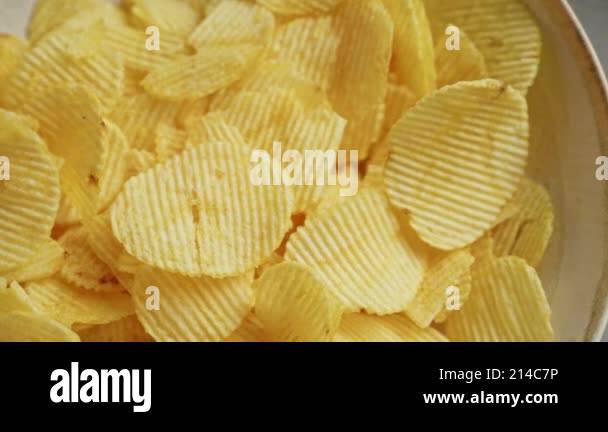Close-up of crisp, golden potato chips in a bowl, capturing the crispy ...