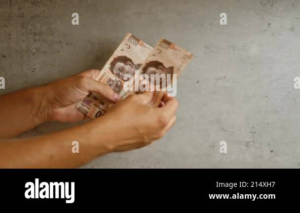Man counting mexican peso banknotes against a concrete wall Stock Video ...