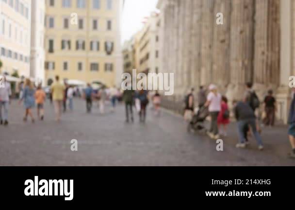 Defocused crowd in historic rome street with architectural columns ...