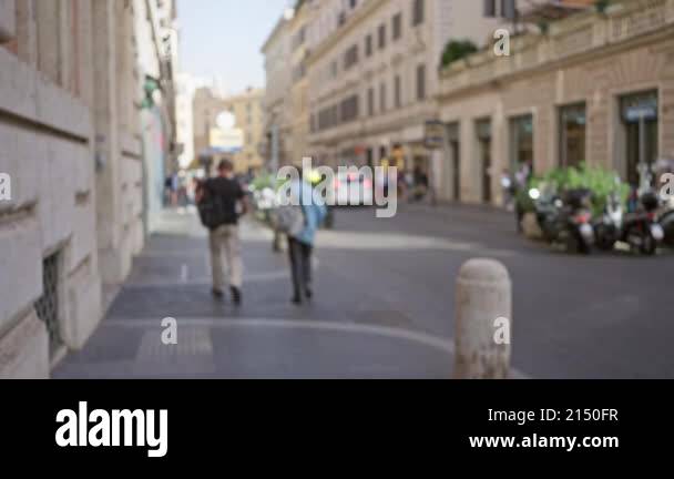 Defocused scene of people walking along a historic street in rome ...
