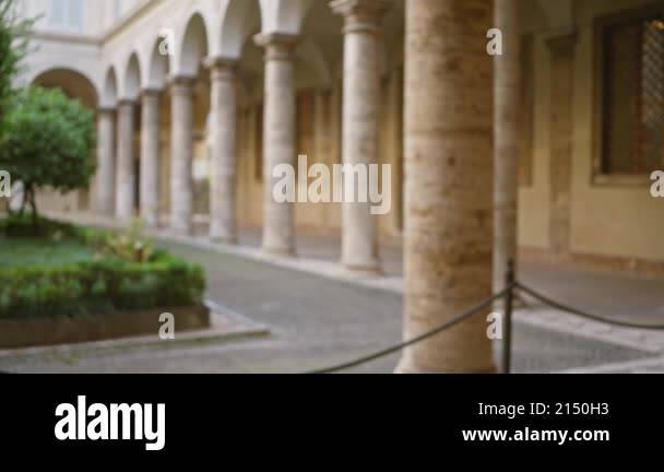 Blurred university campus scene with columns and greenery, capturing an ...
