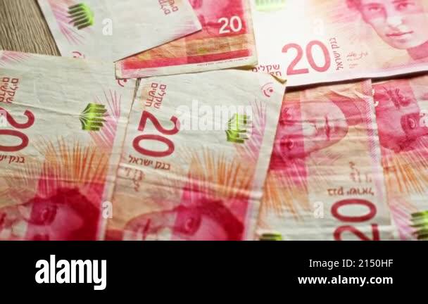 Israeli shekel currency notes in various denominations are scattered on ...