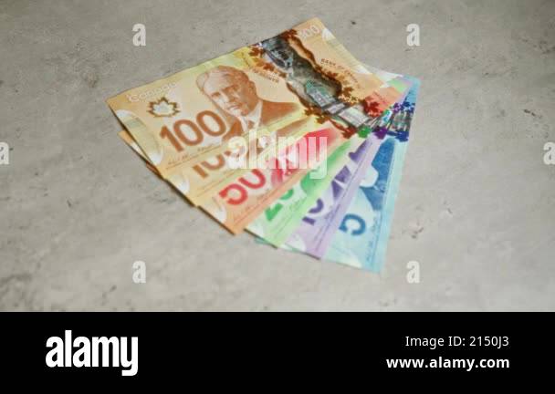 Colorful canadian banknotes displayed on a concrete surface, showcasing ...
