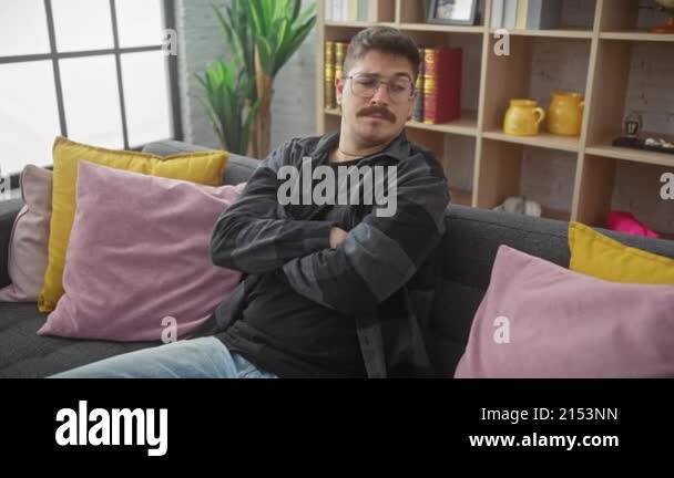 Grumpy young hispanic man with a moustache, skeptically crossed arms on ...