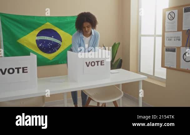 A young woman is casting her vote in an indoor electoral setting with a ...