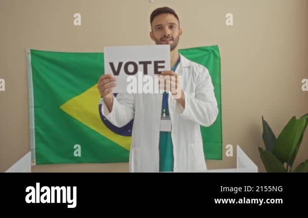 Young hispanic man in a white coat holding a vote sign in an electoral ...