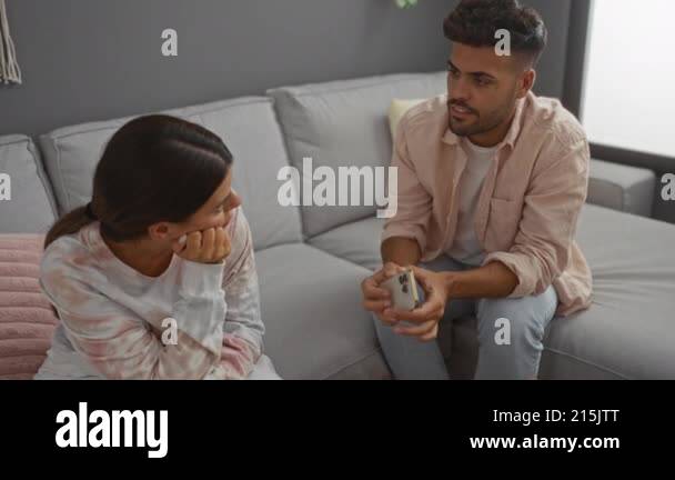 Couple sit together indoors woman listens as man talks home environment ...