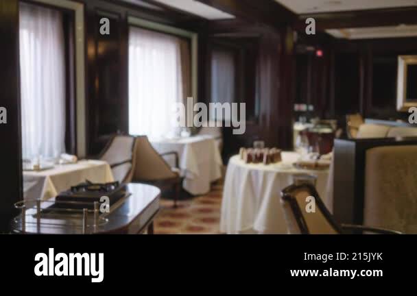 Luxurious restaurant interior with plush chairs, elegantly set tables ...