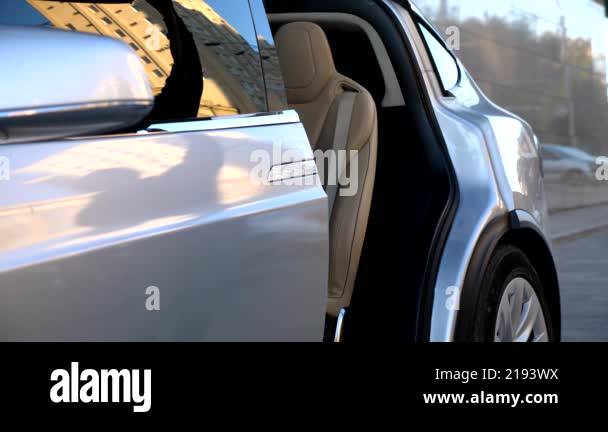 Male hand closing rear passenger door of modern electric SUV car. Arm ...