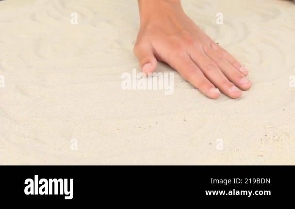 mens hands swarm in the white sea sand. beach games. strokes the sand ...