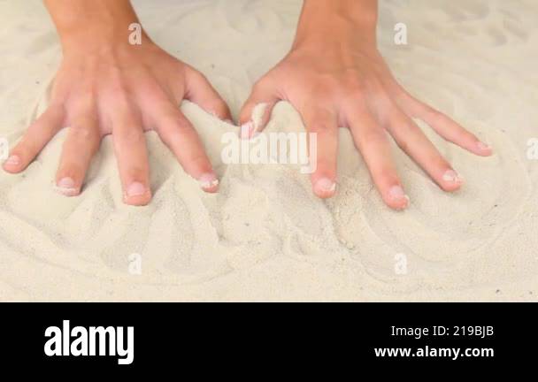 mens hands swarm in the white sea sand. beach games. strokes the sand ...