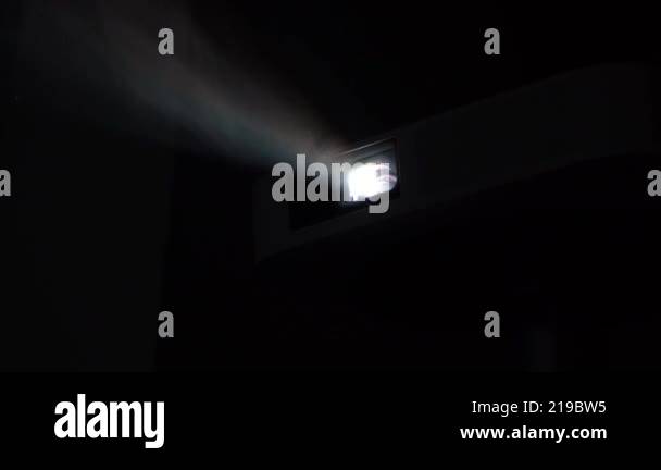 thick smoke glows in the spotlight beams. A home movie projector shines ...