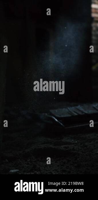 small dust particles glow on a sunbeam in a dark room close-up ...