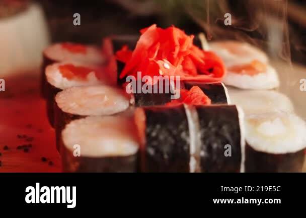 Sushi rotates on a black background. Ready-to-eat delicious Japanese ...