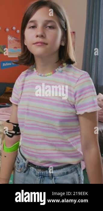 Vertical UGC shot of gen alpha child with upper limb prosthesis turning ...