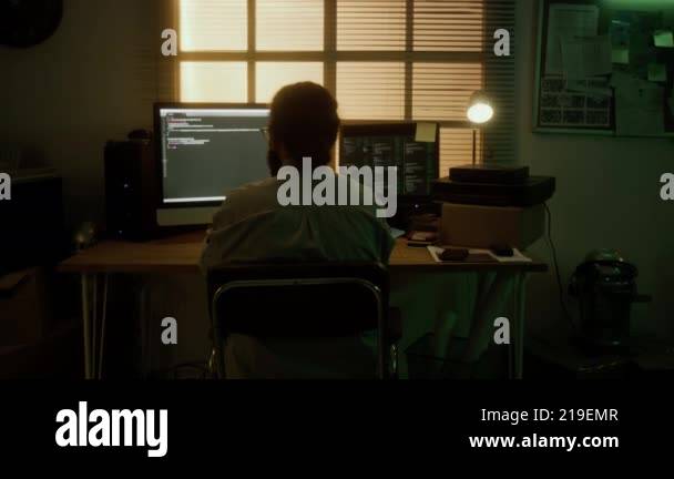 Male programmer sitting at desk and stretching his back and shoulders ...