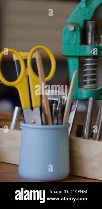 Vertical close-up shot of small container with pair of yellow-handled ...