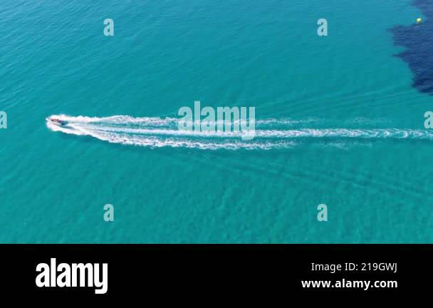 Aerial view of the speed boat in clear blue water at sunset in summer ...