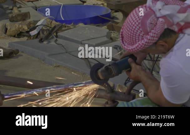 A traditional Arabic blacksmith working in Katara cultural village ...