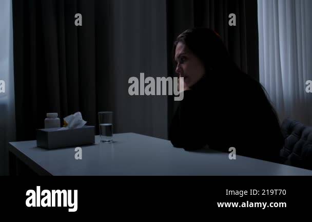 Depressed woman in dark apartment. Woman suffering mental health issues ...