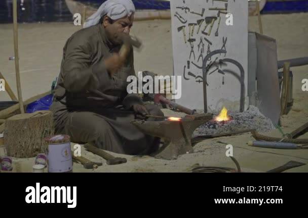 A traditional Arabic blacksmith working in Katara cultural village ...