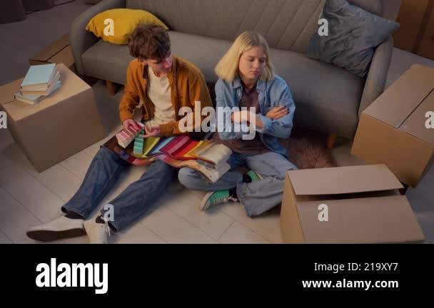 A young man and woman are in the living room discussing a housewarming ...