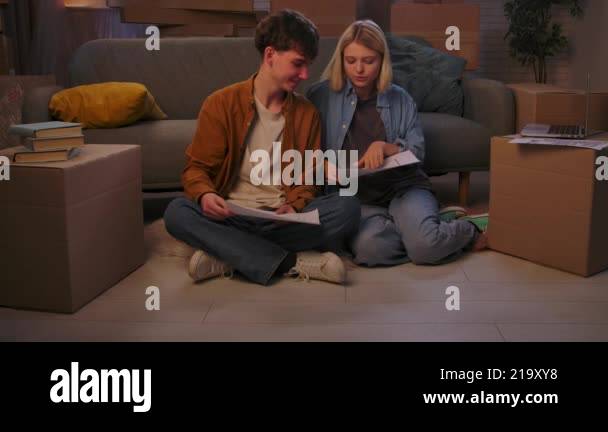 A young man and woman are in the living room discussing a housewarming ...