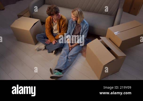 A young man and woman are in the living room discussing a housewarming ...