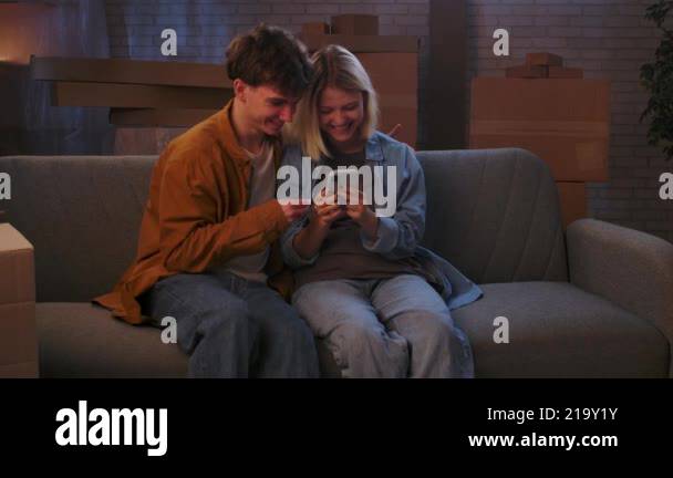 A young man and woman are in the living room discussing a housewarming ...