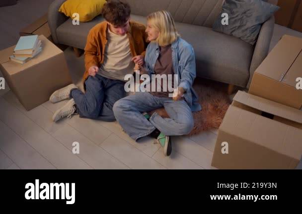 A young man and woman are in the living room discussing a housewarming ...