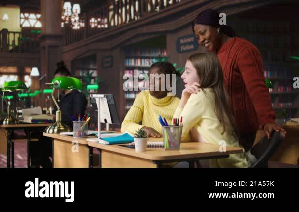 Classmates friends doing a school team project with teacher while on ...