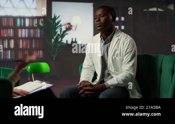 Professional counselor in therapy session with black medic experiencing ...