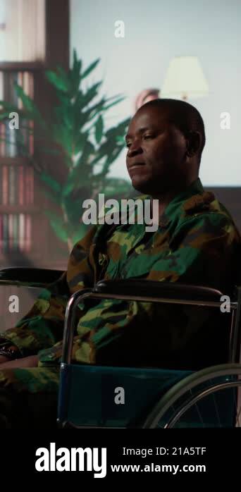 Vertical Video Black army soldier in wheelchair is a war survivor and deals with shell shock ...