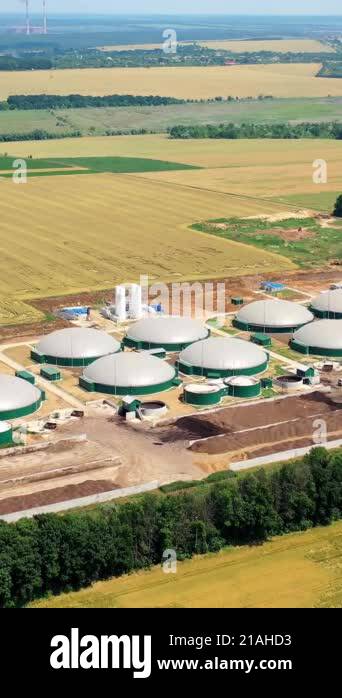 Innovative plant on yellow field. Biogas plant and storage tanks ...